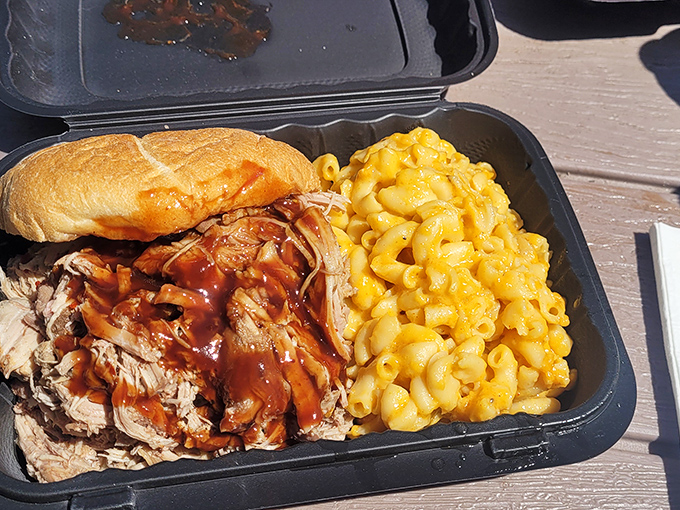 The pulled pork sandwich – where tender strands of smoke-kissed meat meet sauce in a dance as harmonious as Fred and Ginger, with mac and cheese playing backup.