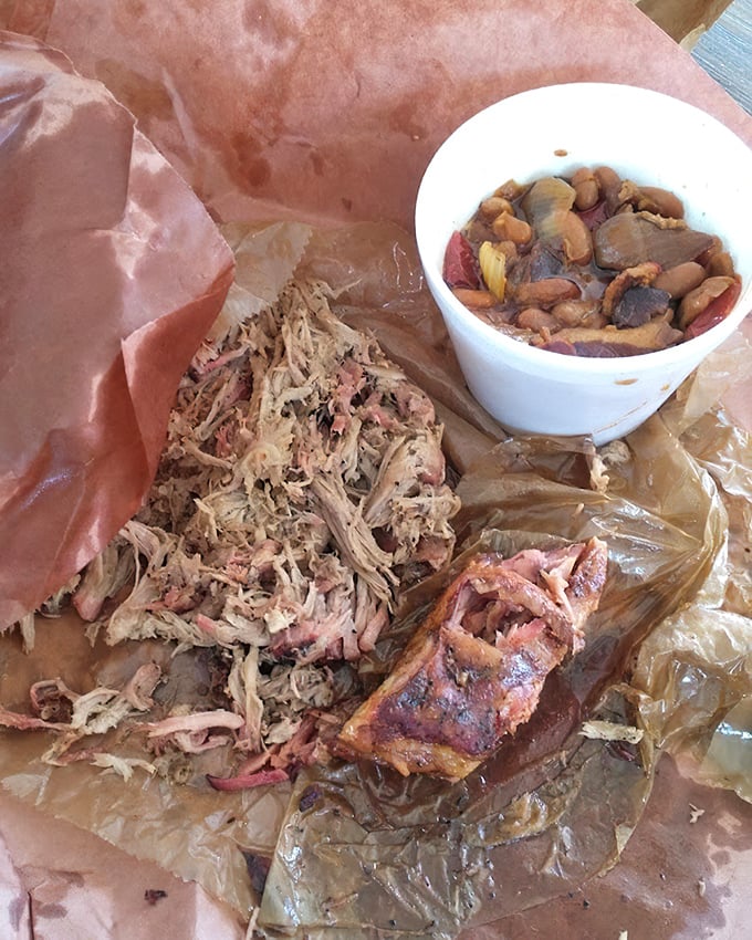 Pulled pork that's spent so much time with smoke it could probably start its own fire. Those beans look like they've been taking notes.