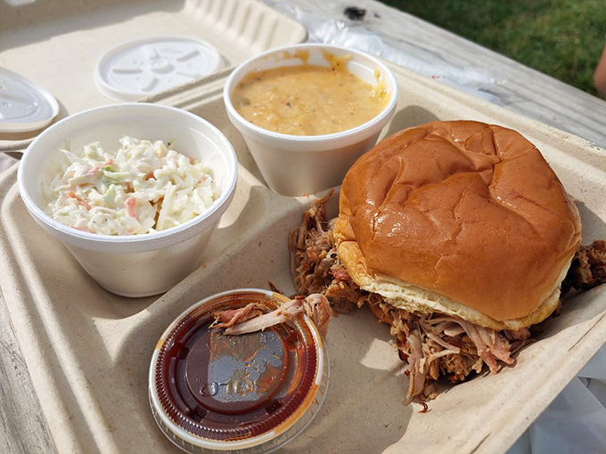 The pulled pork sandwich that launched a thousand road trips, flanked by creamy coleslaw and mac & cheese that demand equal attention.