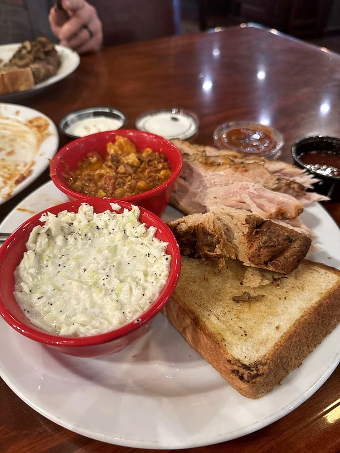 Red bowls of delight—where coleslaw provides creamy counterpoint to what appears to be Brunswick stew, with Texas toast standing by for cleanup duty.