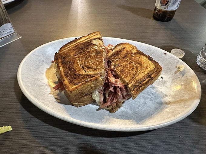 The Reuben sandwich, sliced to reveal its secrets: layers of corned beef, sauerkraut, and melted Swiss that would make any deli proud.