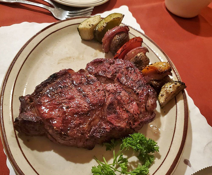 The ribeye arrives like a meaty masterpiece—charred edges, rosy center, and vegetables that know their supporting role perfectly.