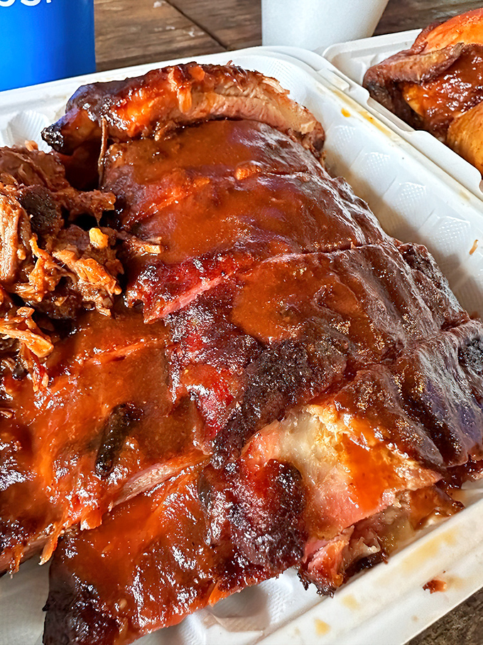 These ribs don't just fall off the bone—they practically leap into your mouth, glistening with that perfect lacquer of sauce and smoke.