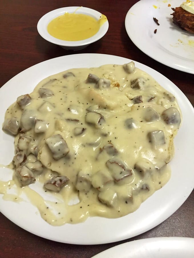 Biscuits swimming in creamy sausage gravy—the kind of dish that makes you want to hug the chef and schedule a cholesterol test.