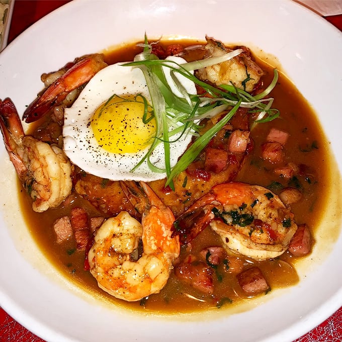 Shrimp and grits elevated to an art form—cajun shrimp swimming in savory broth with a sunny egg playing lifeguard on top.