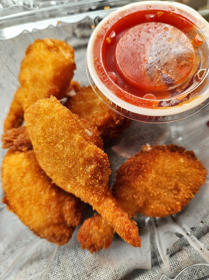 Golden-fried seafood that would make Neptune himself swim to shore. Crispy exterior, tender interior, and that dipping sauce—a simple pleasure that defies improvement.
