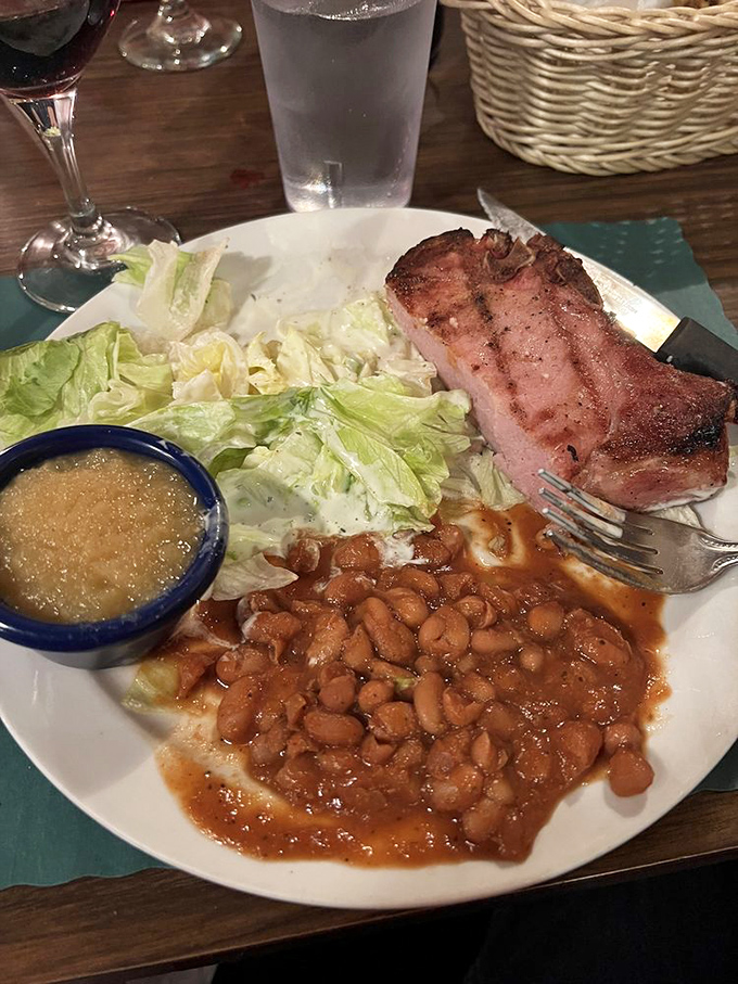 This smoked pork chop isn't just dinner—it's edible poetry. The beans aren't a side dish; they're a supporting actor deserving their own award.