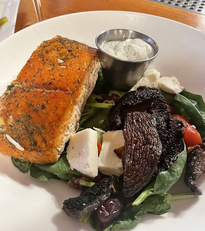 Salmon that doesn't just flake—it practically narrates its own journey from stream to plate, accompanied by roasted mushrooms that deserve their own fan club.