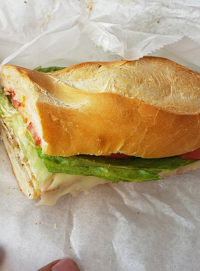 A perfect Italian hoagie in its natural habitat – crisp lettuce, quality meats, and that bread! This is sandwich architecture at its finest.