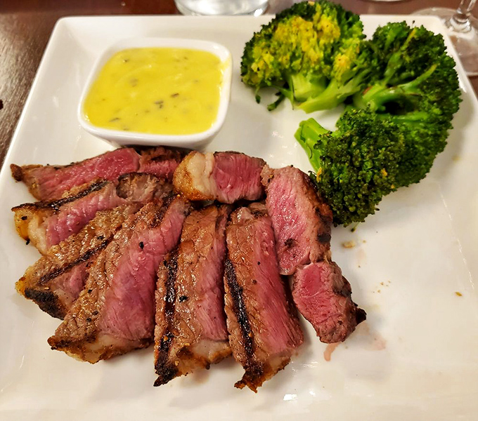 A perfectly medium-rare cut paired with bright broccoli—proof that sometimes the simplest combinations create the most profound pleasure.
