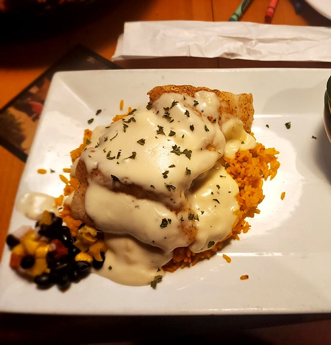 This isn't just fish—it's a cheese-smothered masterpiece resting on a bed of Spanish rice that would make abuela proud.