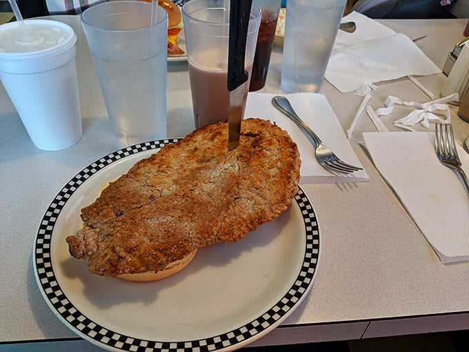 The breaded tenderloin – Indiana's unofficial state sandwich – spilling magnificently over its plate. It's not a meal; it's a challenge worth accepting.