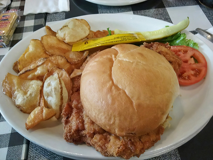 This tenderloin sandwich doesn't just hang over the edge of the plate—it's staging a full-scale rebellion against portion control.