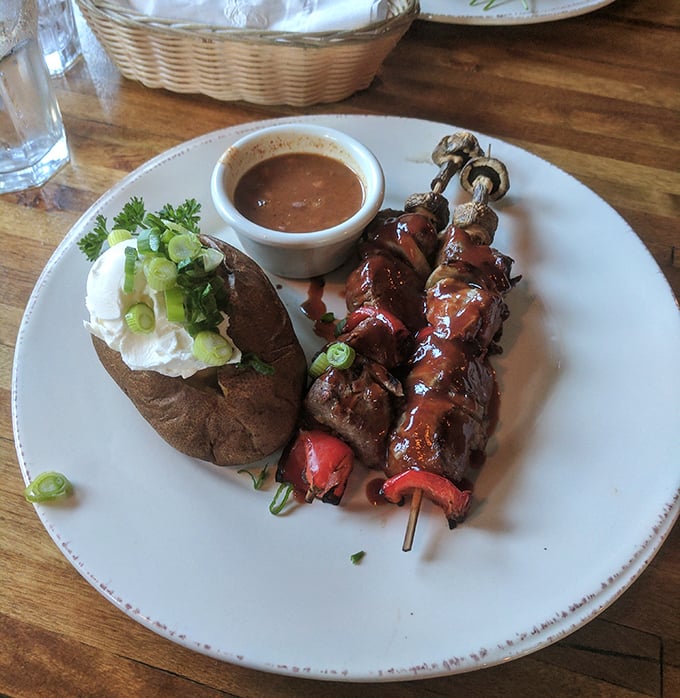 These skewers aren't just food—they're edible exclamation points, served with a baked potato that's dressed better than most people.