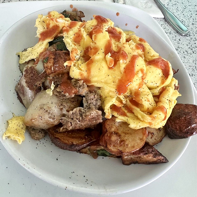 This skillet doesn't just feed your hunger—it tells a story of perfectly seasoned meats, eggs, and potatoes in harmonious breakfast matrimony.