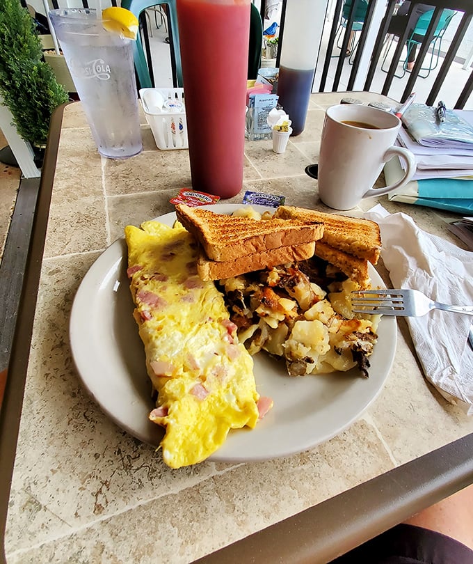The Western omelet and home fries combo—where breakfast dreams come true. That perfect fold hiding savory treasures inside would make any French chef nod in approval.