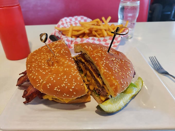 The bacon cheeseburger arrives like a beautiful, messy sonnet to simplicity—where every ingredient plays its part without unnecessary culinary jazz hands.
