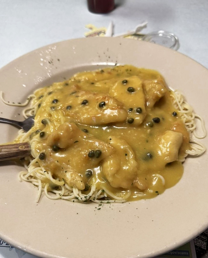 Chicken piccata over pasta shows the diner's dinner chops—tender chicken swimming in a lemony sauce dotted with capers like tiny flavor grenades.