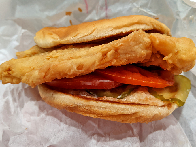 Behold the chicken sandwich in its natural habitat—crispy, golden-fried goodness nestled between soft buns with fresh veggies standing by.
