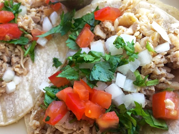 These street tacos aren't trying to impress Instagram—they're too busy delivering perfect bites of seasoned meat, fresh cilantro, and diced onion.