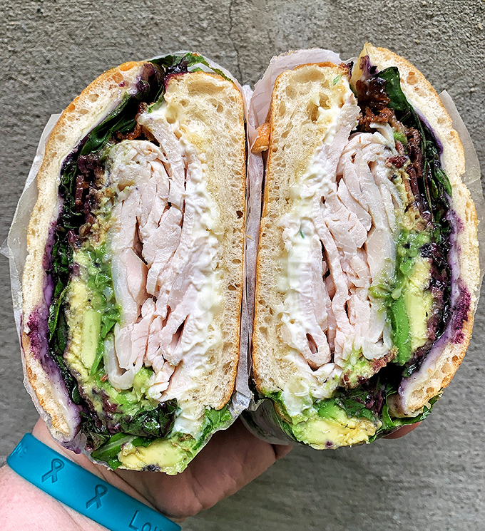 Layer upon layer of turkey, avocado and greens—this club sandwich isn't just stacked, it's architecturally sound enough to impress Frank Gehry.