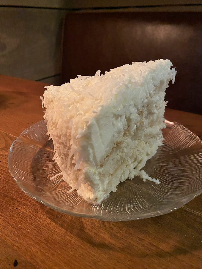 A slice of coconut cake that would make your grandmother both proud and jealous. Those layers aren't just dessert—they're architecture.