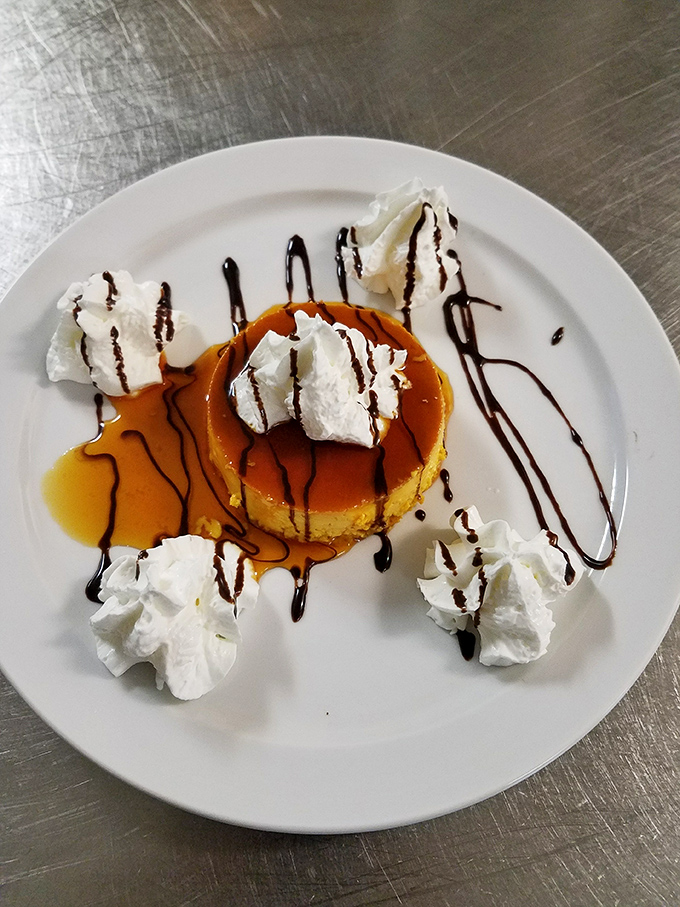 This flan isn't just dessert—it's a caramel-crowned masterpiece surrounded by whipped cream islands, proving simple pleasures are often the most profound.