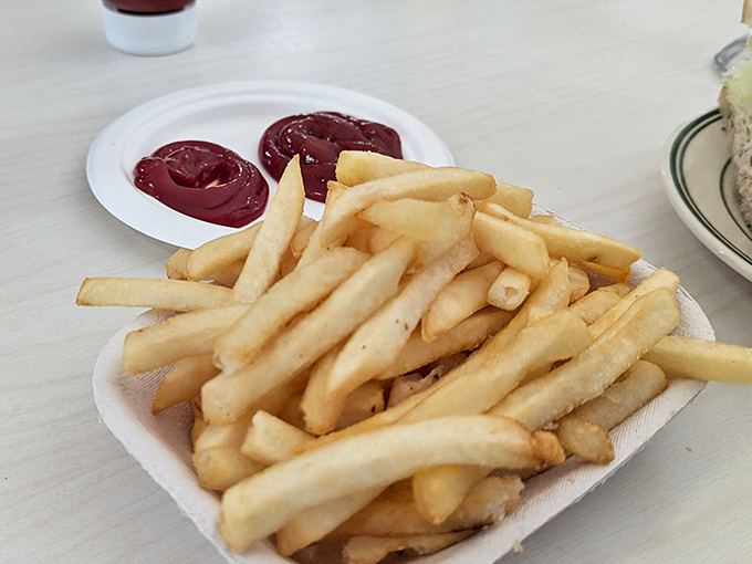 French fries served in a paper cup – simple, golden, perfect. No truffle oil, no duck fat, no nonsense – just potatoes fulfilling their highest purpose.