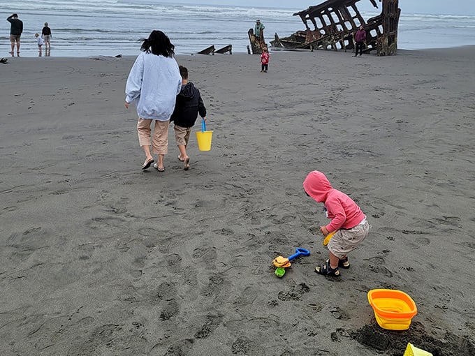 Building sandcastles in the shadow of a shipwreck—childhood wonder meets historical tragedy in this perfect Oregon beach day scenario.