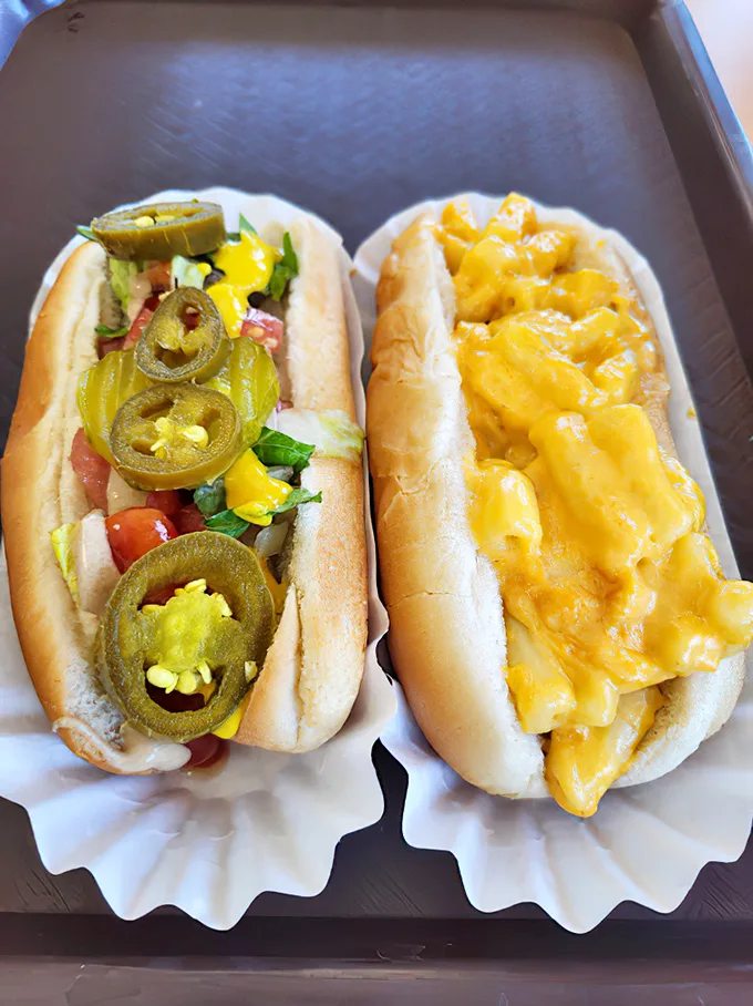 These aren't just any hot dogs—one loaded with jalapeños for heat seekers, the other blanketed in melted cheese that stretches with each bite in a glorious display of comfort food perfection.