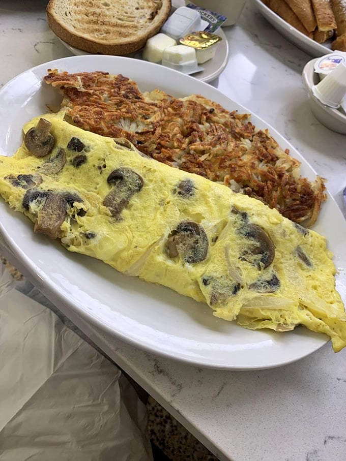 Behold the mushroom whisperer's masterpiece—an omelet that proves eggs and fungi were destined for each other, with hash browns playing matchmaker.