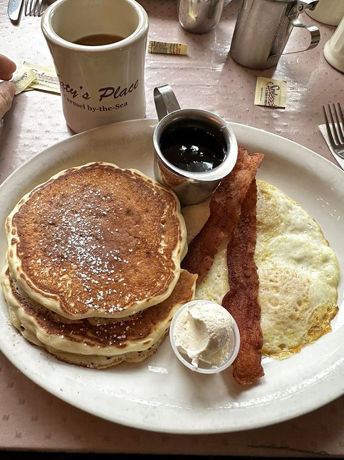 The breakfast trinity: golden pancakes, crispy bacon, and a sunny-side-up egg – proof that sometimes the classics are classics for good reason.