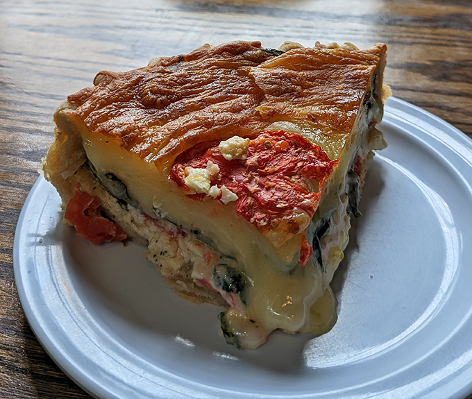 A slice of quiche that's having an identity crisis – is it breakfast? Lunch? The answer is yes, and it's magnificent either way.