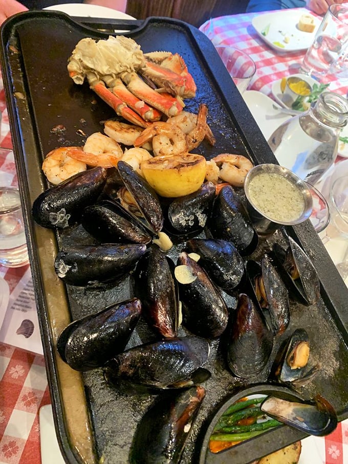 The seafood skillet arrives like Neptune's personal feast—mussels, crab legs, and shrimp glistening with garlic butter that demands to be sopped up.