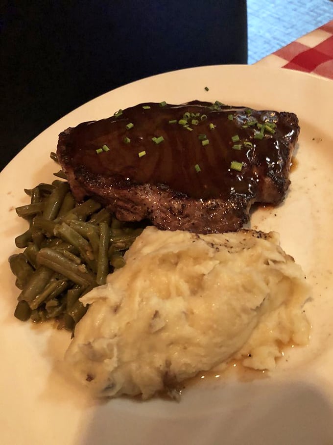 This isn't just a steak; it's a masterclass in simplicity – perfectly seared, resting on green beans with a side of mashed potatoes that look cloud-soft.