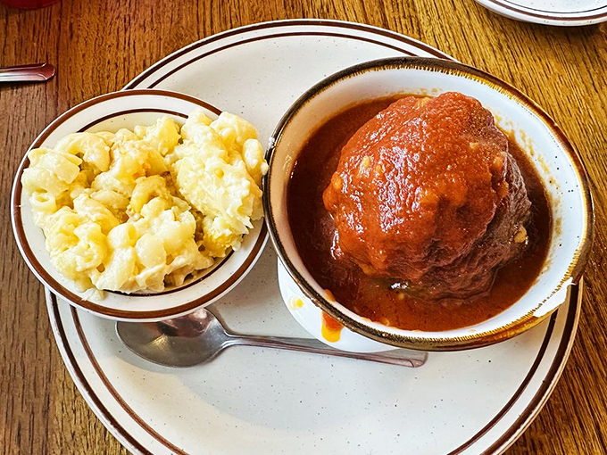 Meatloaf smothered in rich gravy alongside creamy mac and cheese—the kind of plate that makes you want to hug the chef afterward.