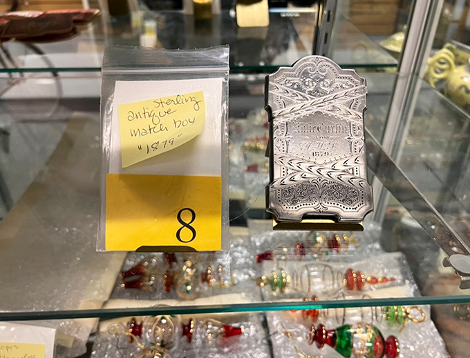 An antique sterling matchbox sits patiently under tag #8, waiting for someone who appreciates history you can actually hold.