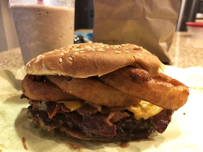 This bacon cheeseburger with onion rings isn't just breaking the rules of proper burger construction—it's writing delicious new ones.