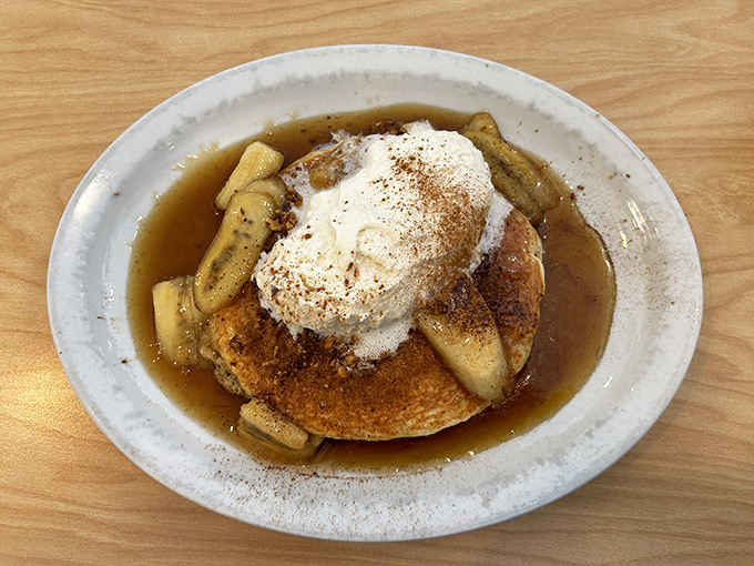 Bananas Foster pancakes crowned with a cloud of whipped cream—dessert masquerading as breakfast, and nobody's complaining.