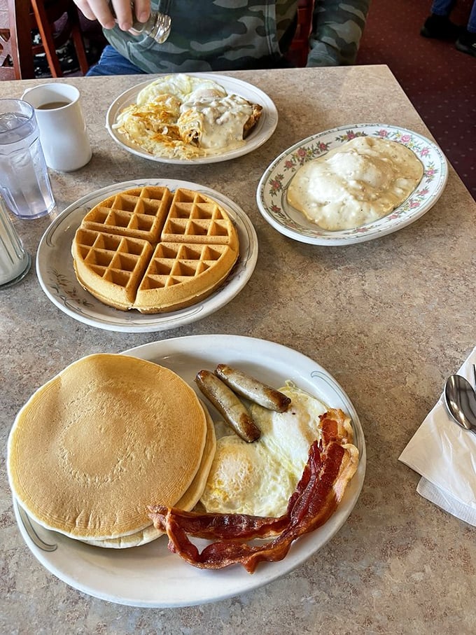 Breakfast of champions: golden waffle, perfectly cooked eggs, crispy bacon, and pancakes that could double as pillows in a breakfast-themed dream.