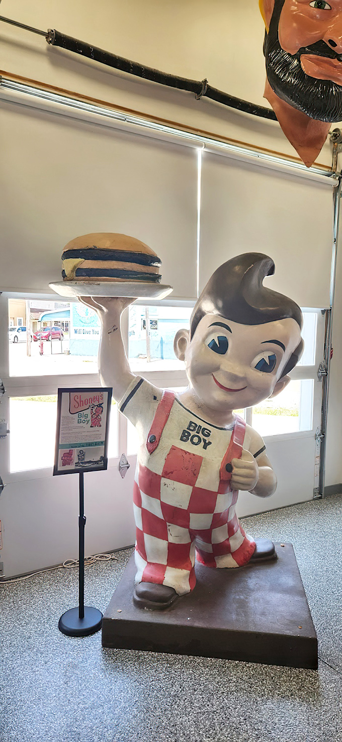 The iconic Big Boy statue, with his checkered overalls and famous pompadour, still hoists that burger skyward—a fiberglass promise of roadside comfort food.