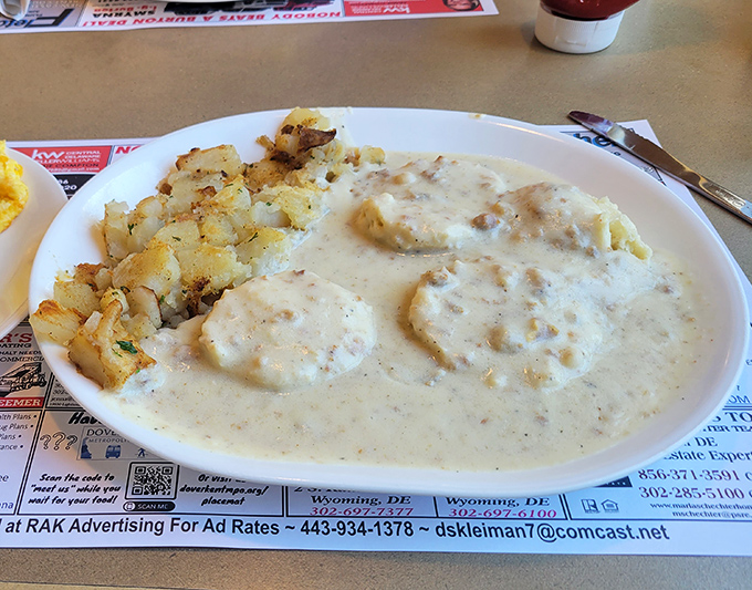 Biscuits swimming in peppery sausage gravy alongside golden home fries—the breakfast equivalent of a warm hug from an old friend.