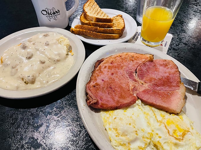 The breakfast trinity: ham steak, eggs, and a bowl of biscuits and gravy that could make a cardiologist weep – with both concern and envy.