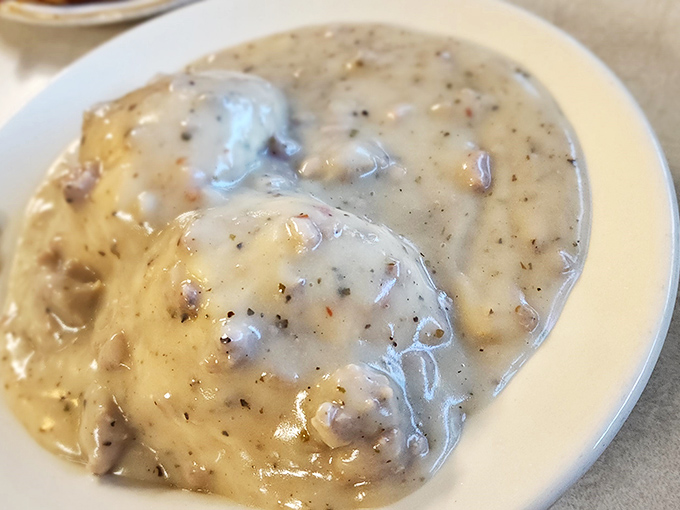 Biscuits and gravy: where pepper-speckled country gravy cascades over fluffy islands of dough—the breakfast equivalent of a warm hug from someone who truly gets you.