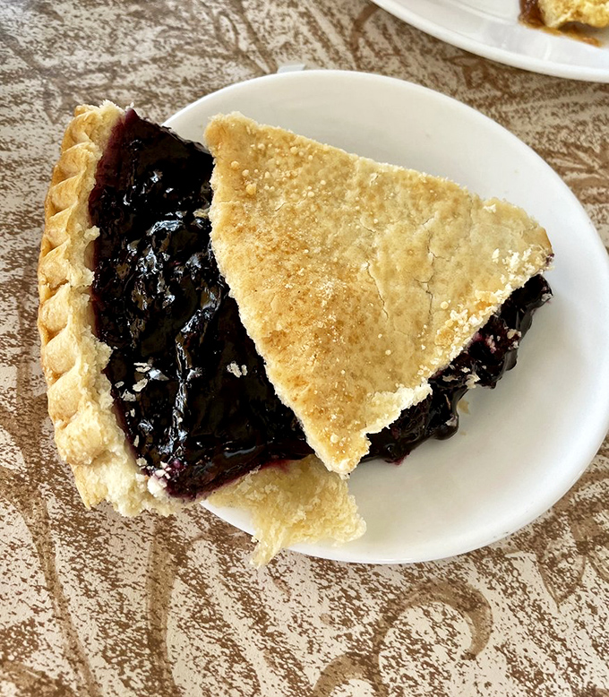 Blueberry pie bursting with fruit like a summer day captured in pastry perfection.