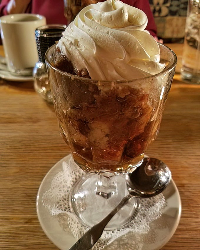 Bread pudding topped with a cloud of whipped cream – the kind of dessert that makes you consider skipping the main course next time.