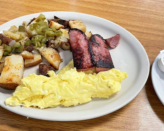 The breakfast trinity: fluffy scrambled eggs, home fries with personality, and ham that didn't come from a package. Simple perfection on a plate.