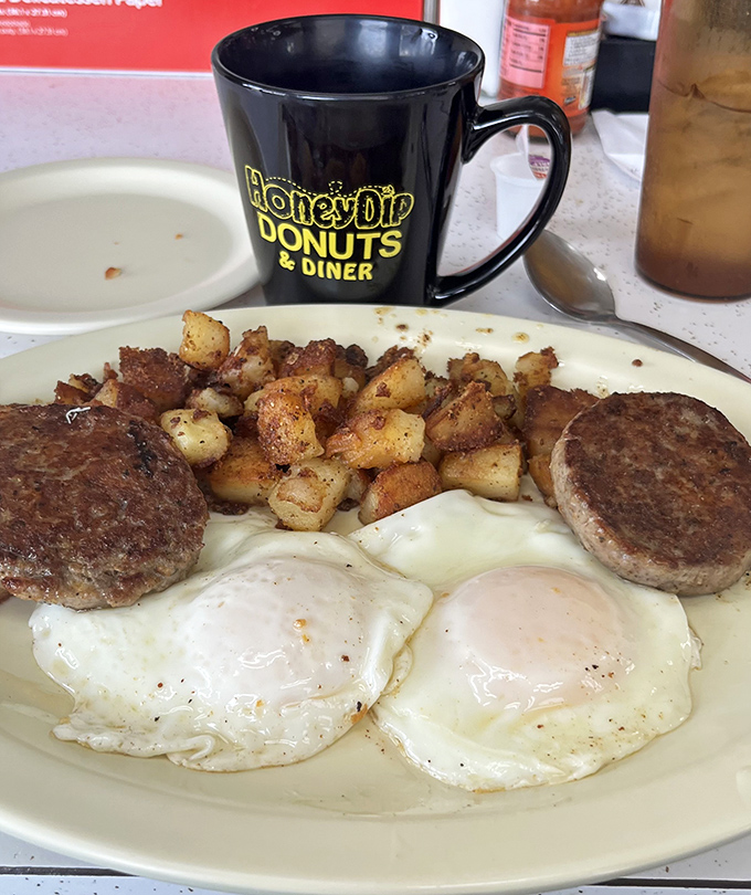 Two eggs, home fries, and sausage patties—the breakfast trinity that's launched a million productive days. Simple perfection on a plate.