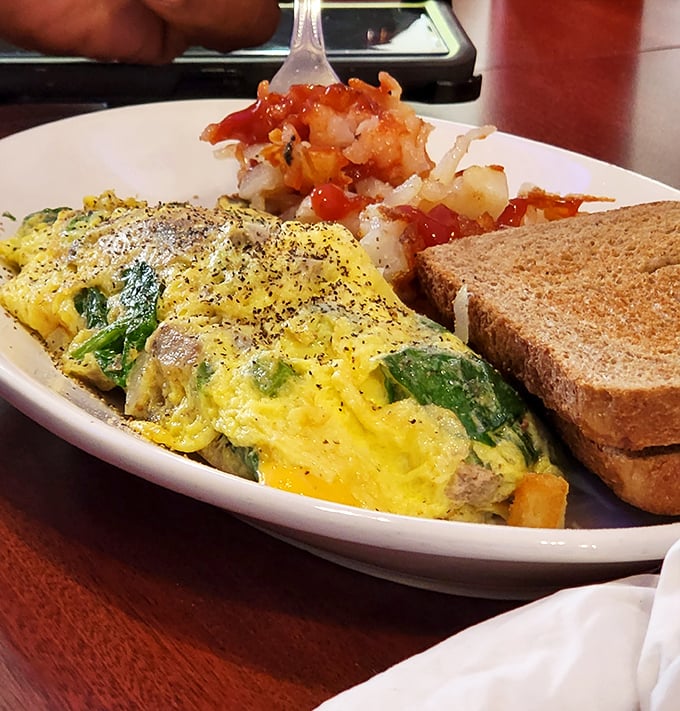An omelet filled with fresh veggies alongside perfectly bronzed hash browns—the breakfast power couple that's been happily married for decades.