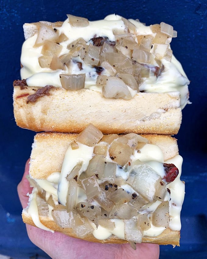 The Brisket Cheesesteak – where Philadelphia tradition meets Texas smoke in a handheld miracle. Cooper Sharp cheese sauce cascades over tender brisket like a dairy waterfall.